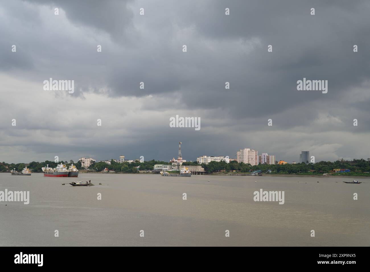 Heavy monsoon clouds hover over the Ganges, with the Kolkata skyline in ...