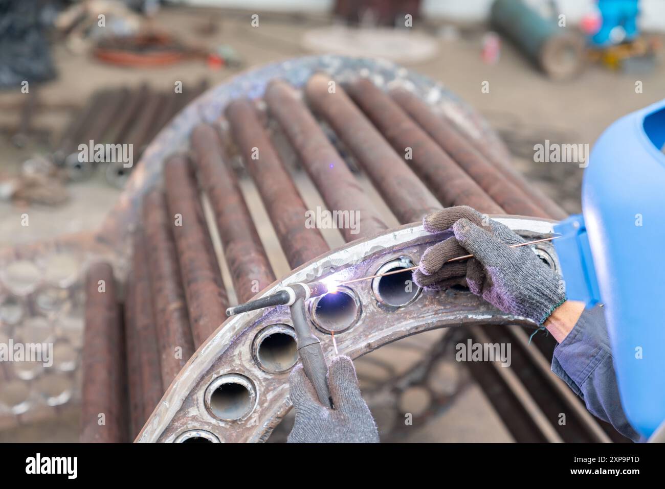 Worker is welding metal tubes, man hand welding boiler with argon gas ...