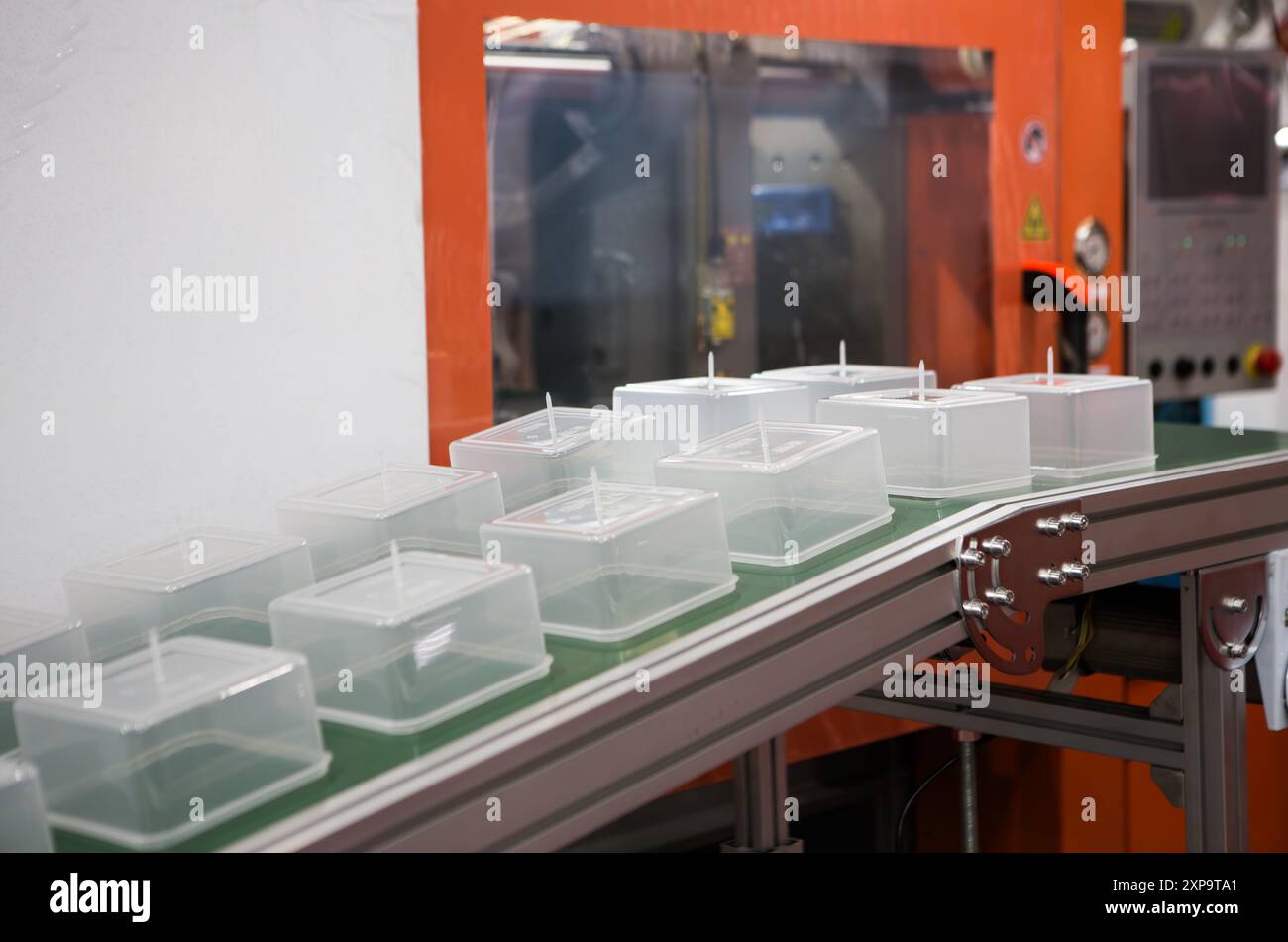 Plastic food containers on conveyor belt from plastic injection molding ...