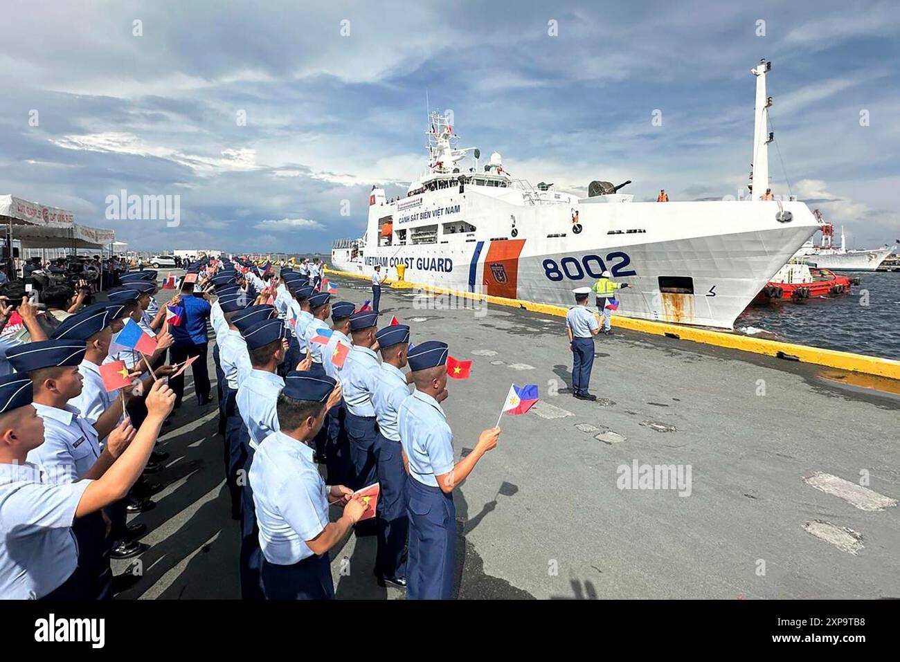 Philippine Coast Guard personnel wave Vietnamese and Filipino flags to ...