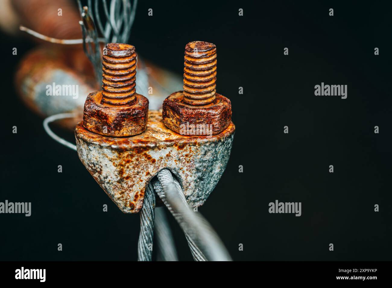 Rusty metal clamp holding steel cable tightly together, A symbol of ...