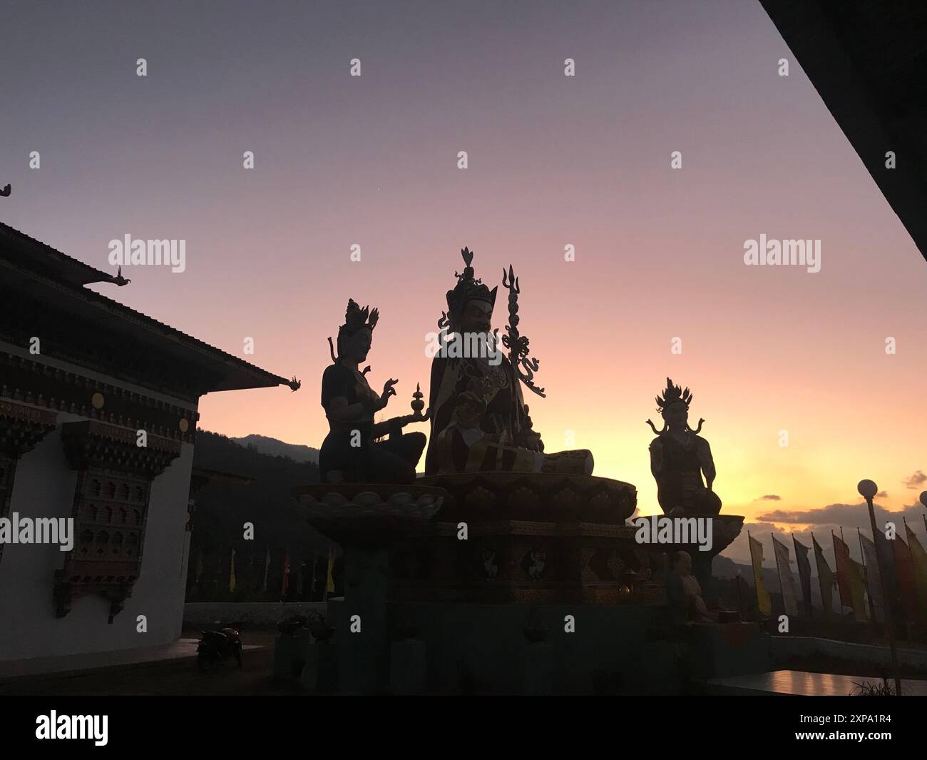 The silhouette of statues at a temple during sunset in Bhutan Stock ...