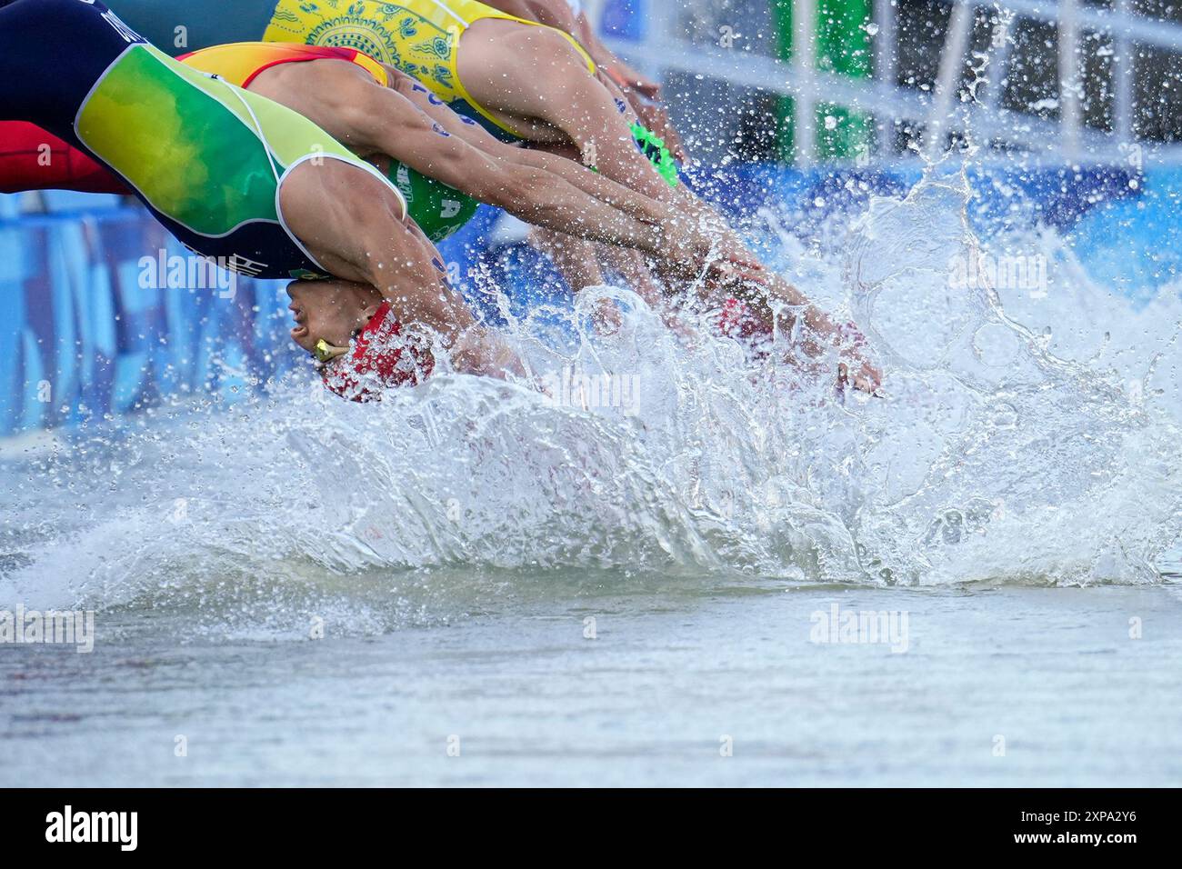 Athletes dive into the water for the start of the mixed relay triathlon ...