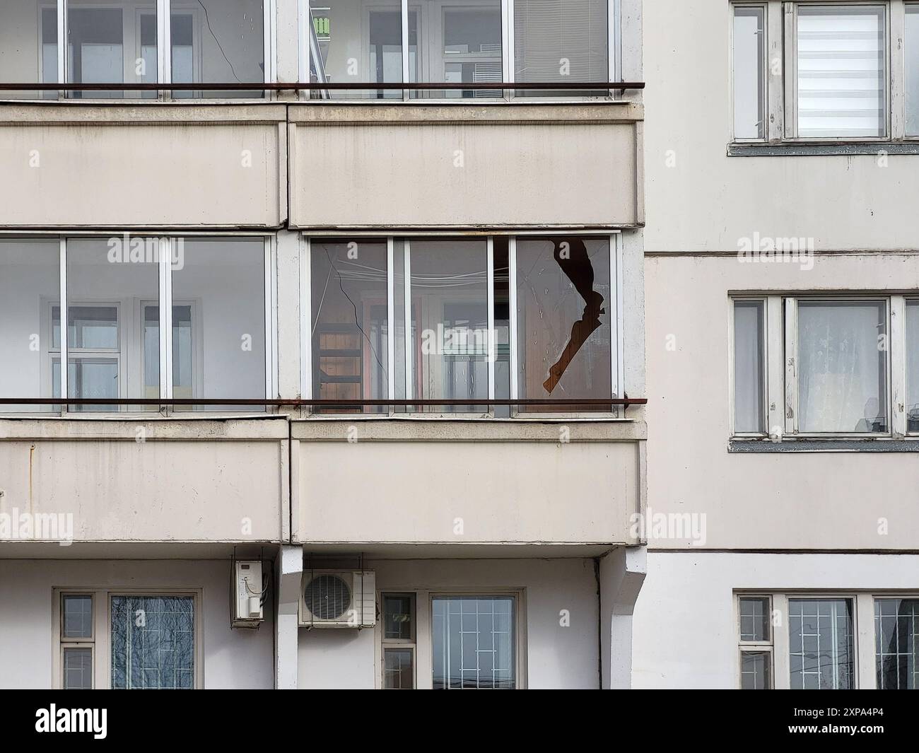 Facade of an apartment building with a broken window on a balcony ...