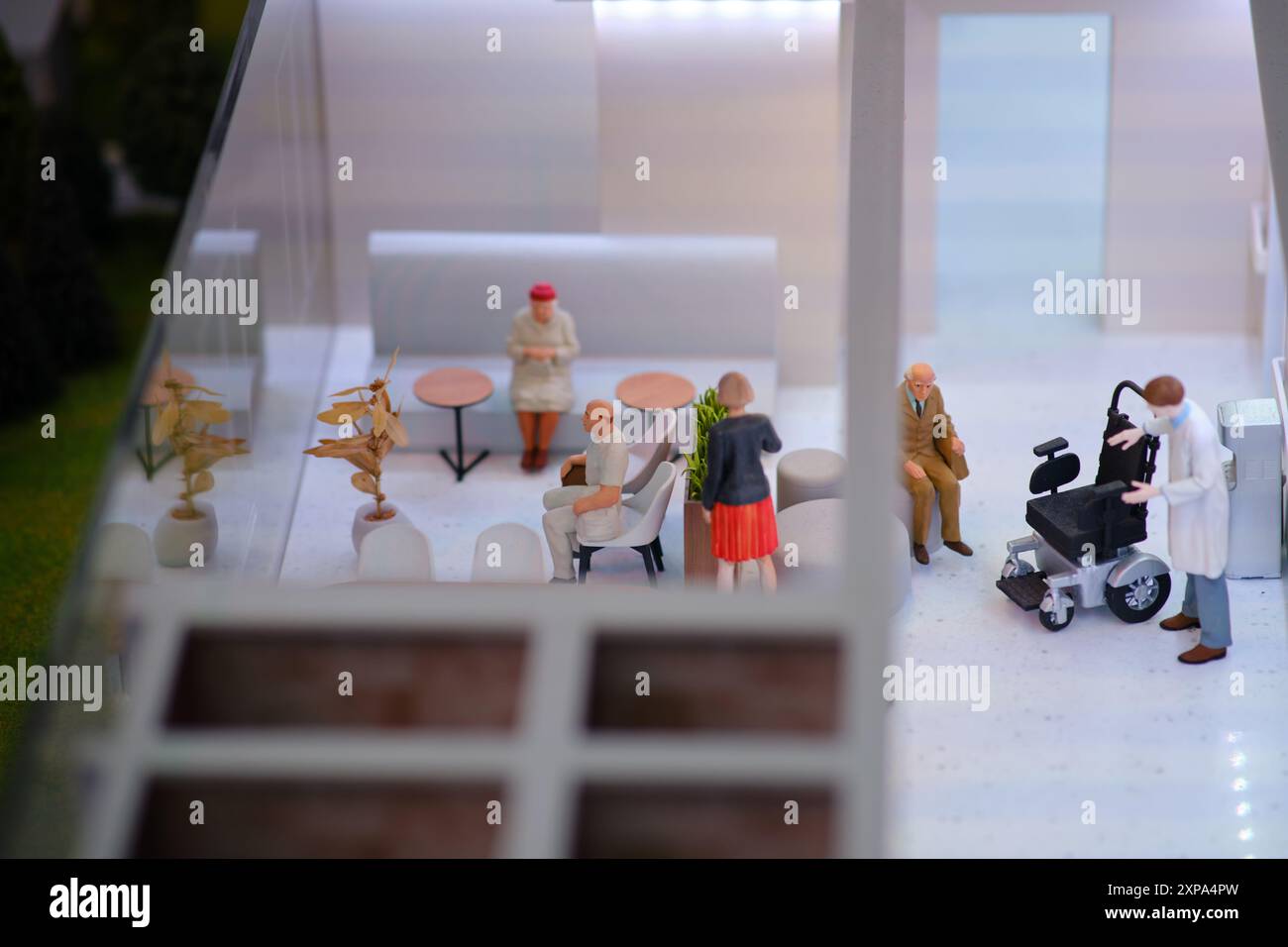 Model of healthcare facility with miniature people in a waiting area ...
