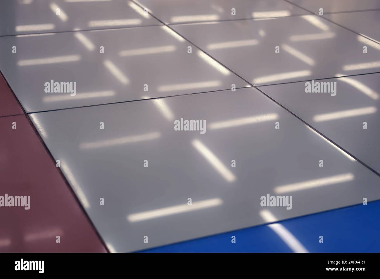 Reflective white and colored floor tiles with fluorescent light ...