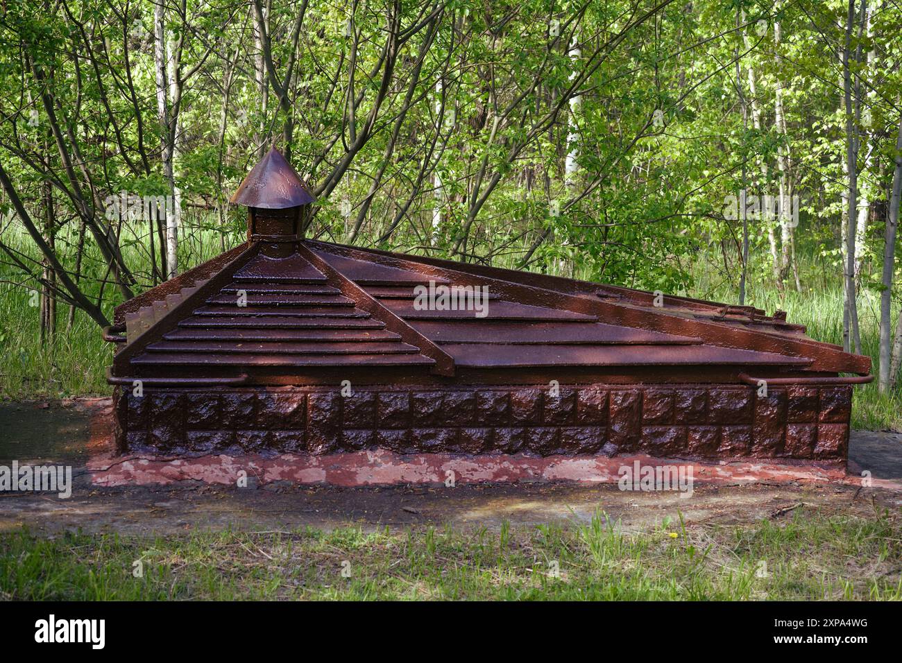 Old rusty metal ventilation shaft in a forest setting. Industrial ...
