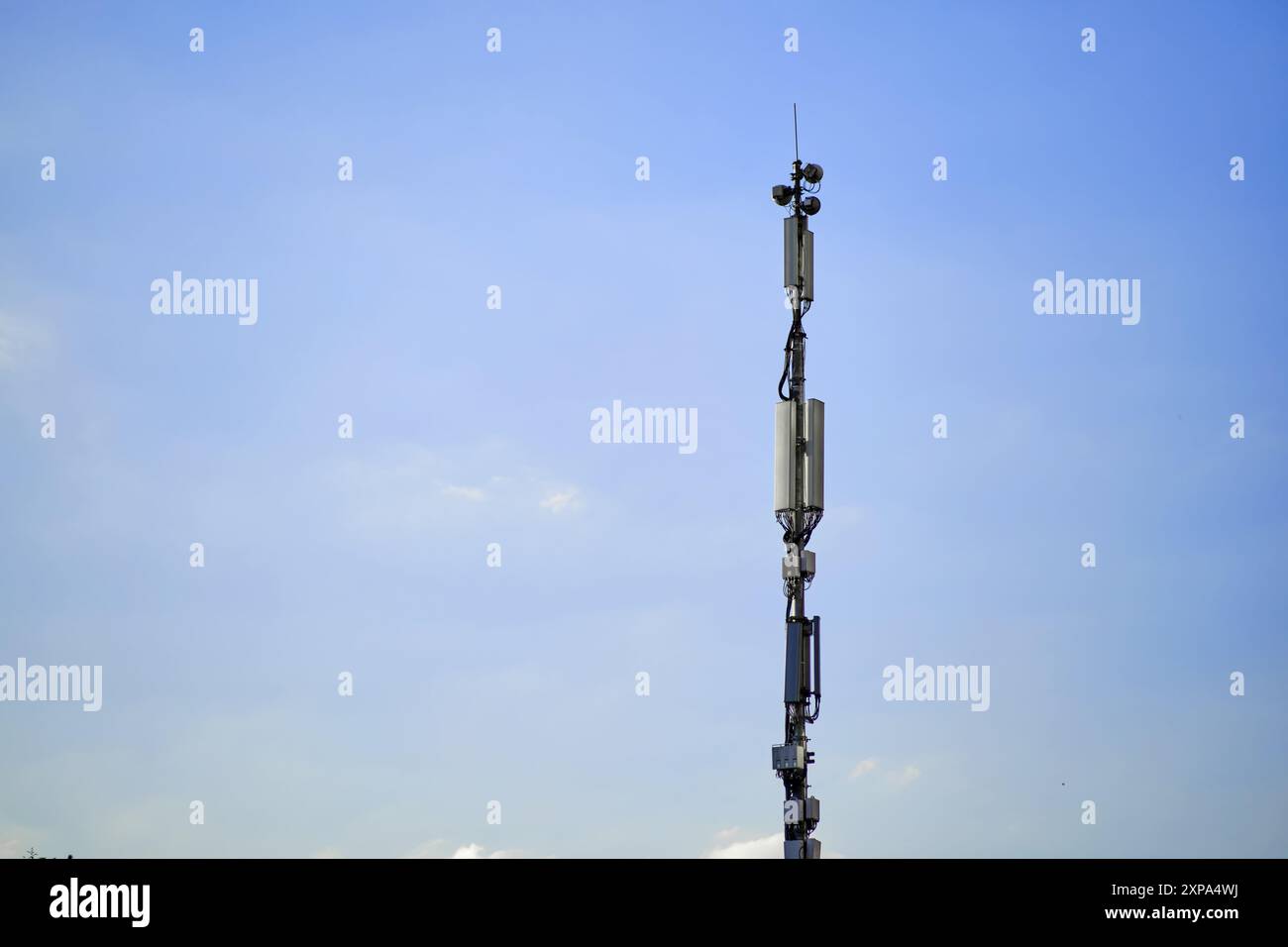 Telecommunication tower with antennas against a clear blue sky. Outdoor technology photography ...