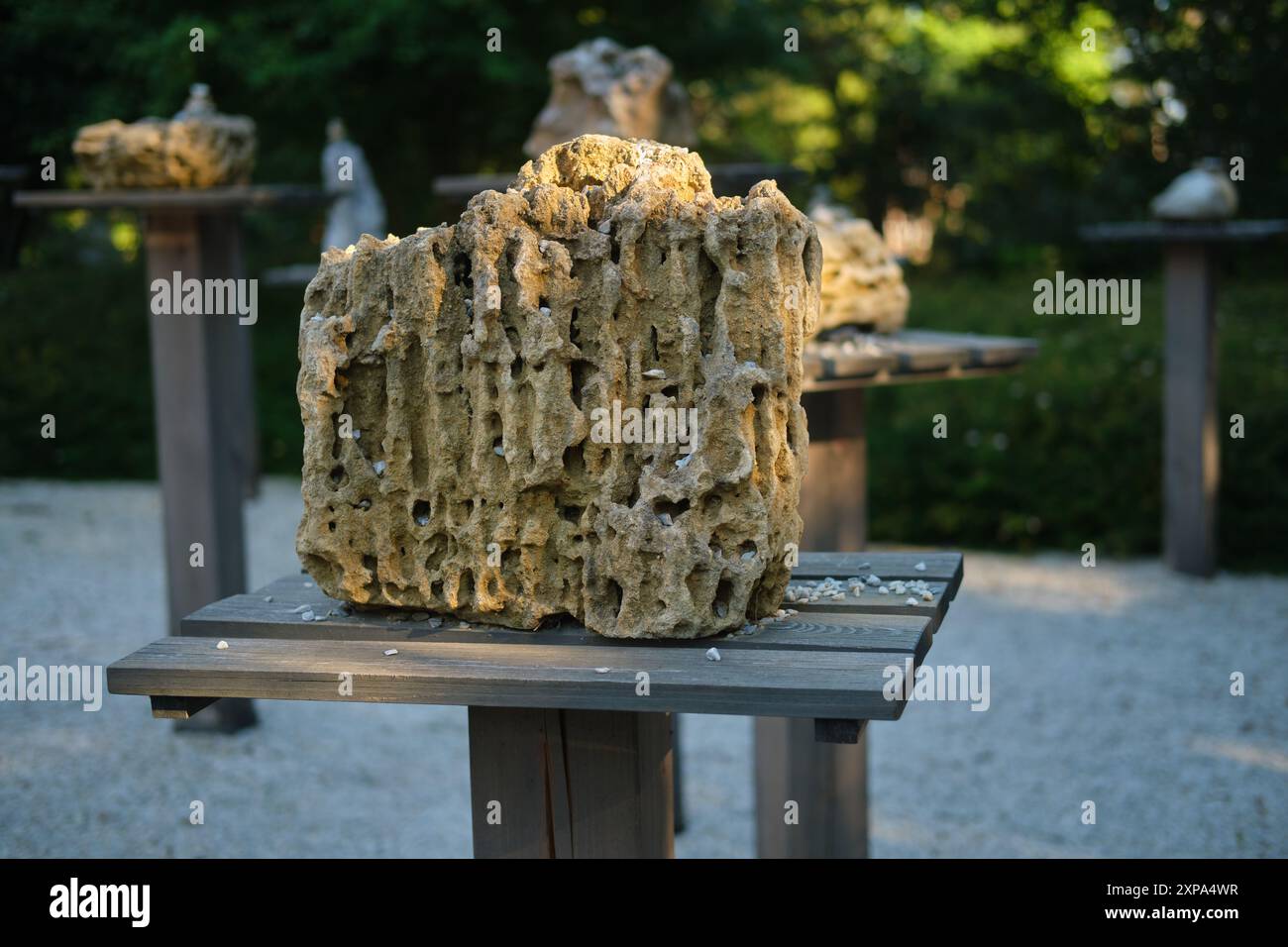 Natural stone sculpture with porous texture displayed on a wooden ...