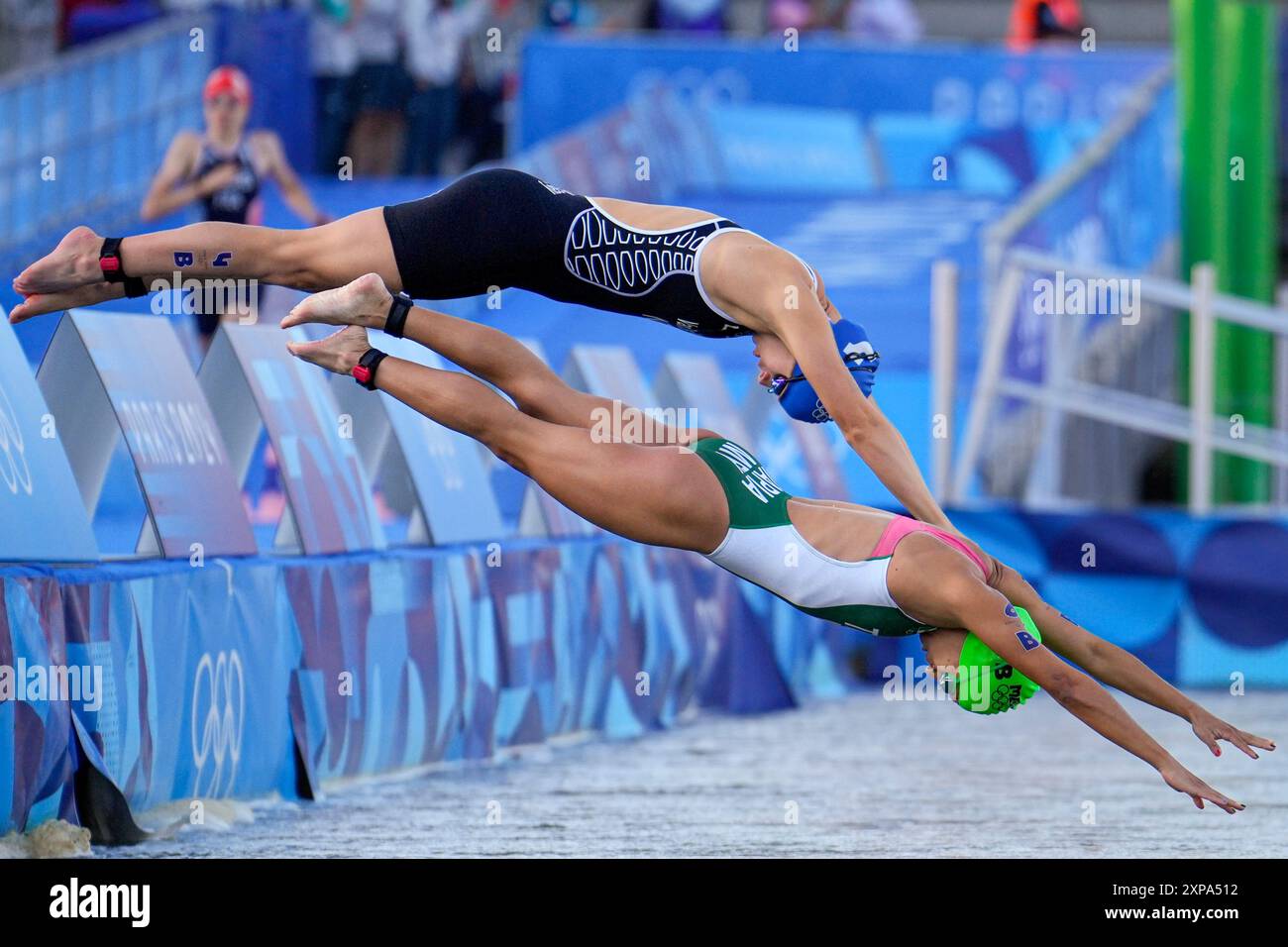 New Zealand's Ainsley Thorpe, up, dives into the water for the start of ...