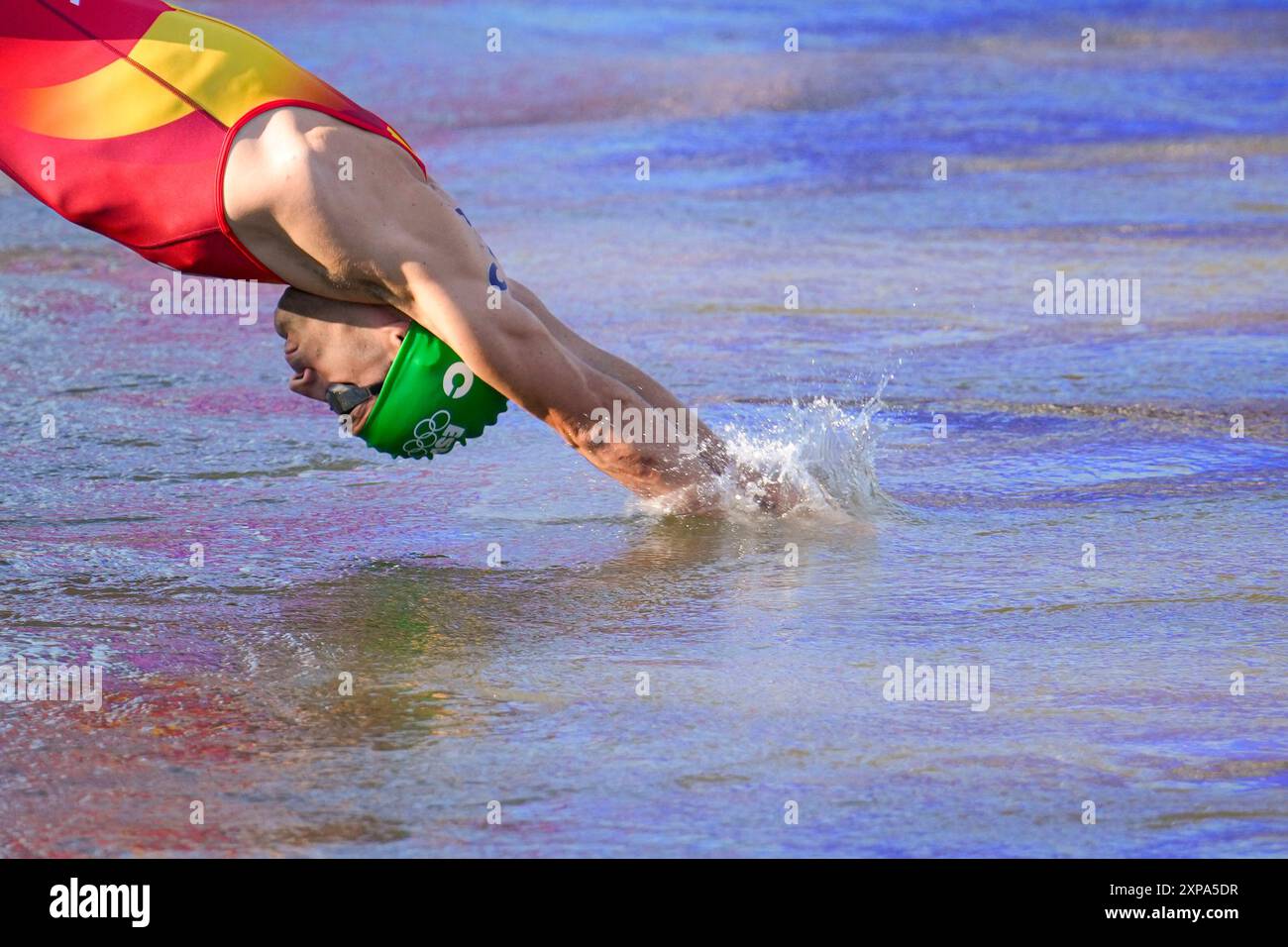 Spain's Antonio Serrat Seoane dives into the water during the swim leg ...