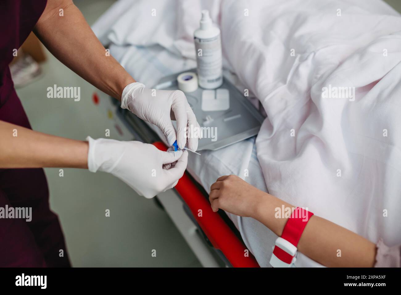 Close up of nurse insering IV cannula in little girl hand. IV ...