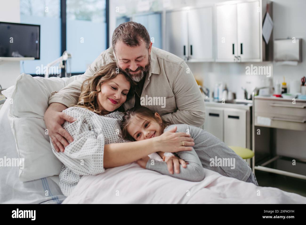 Father and daughter visiting mother in hospital after surgery ...