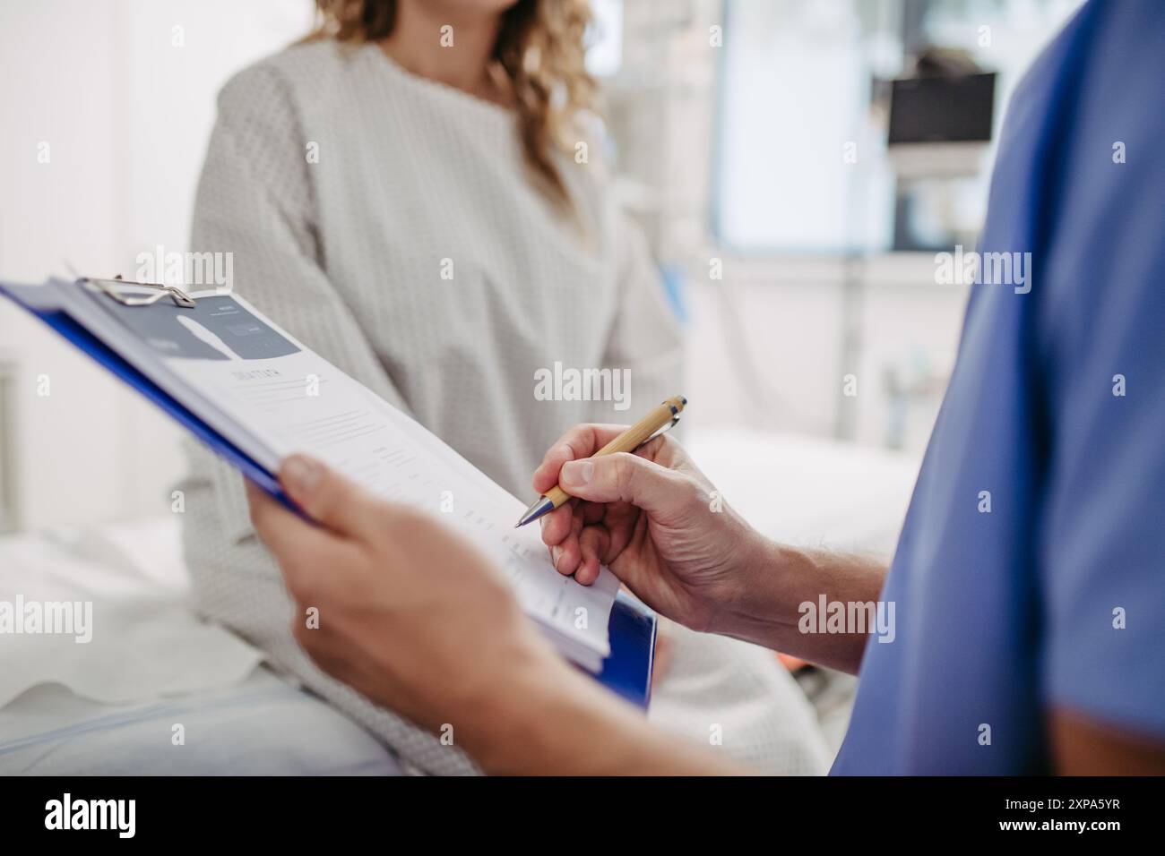 Doctor talking with worried patient before surgery, writing medical ...