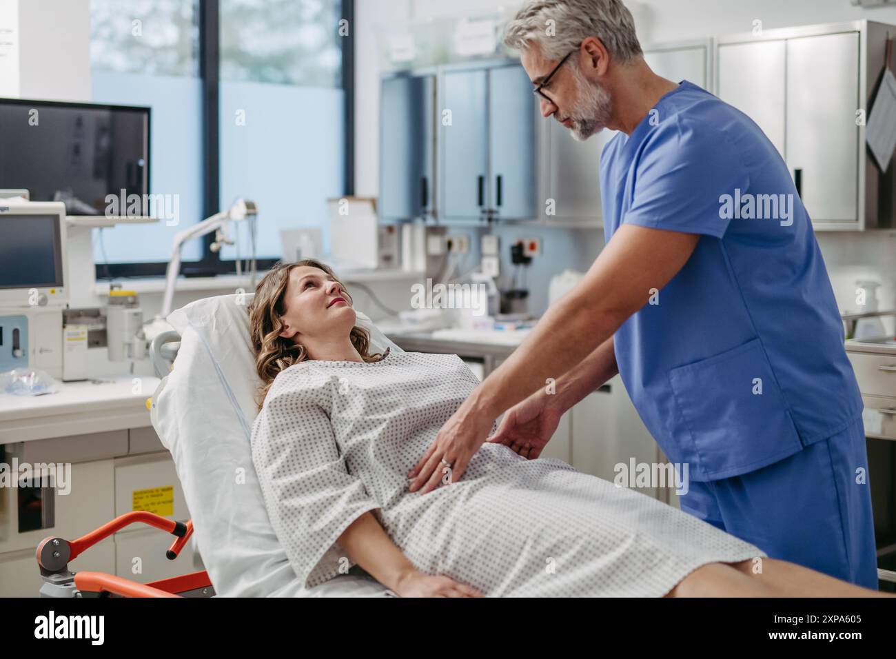 Doctor palpating woman's abdomen, using hands and steady pressure Stock ...