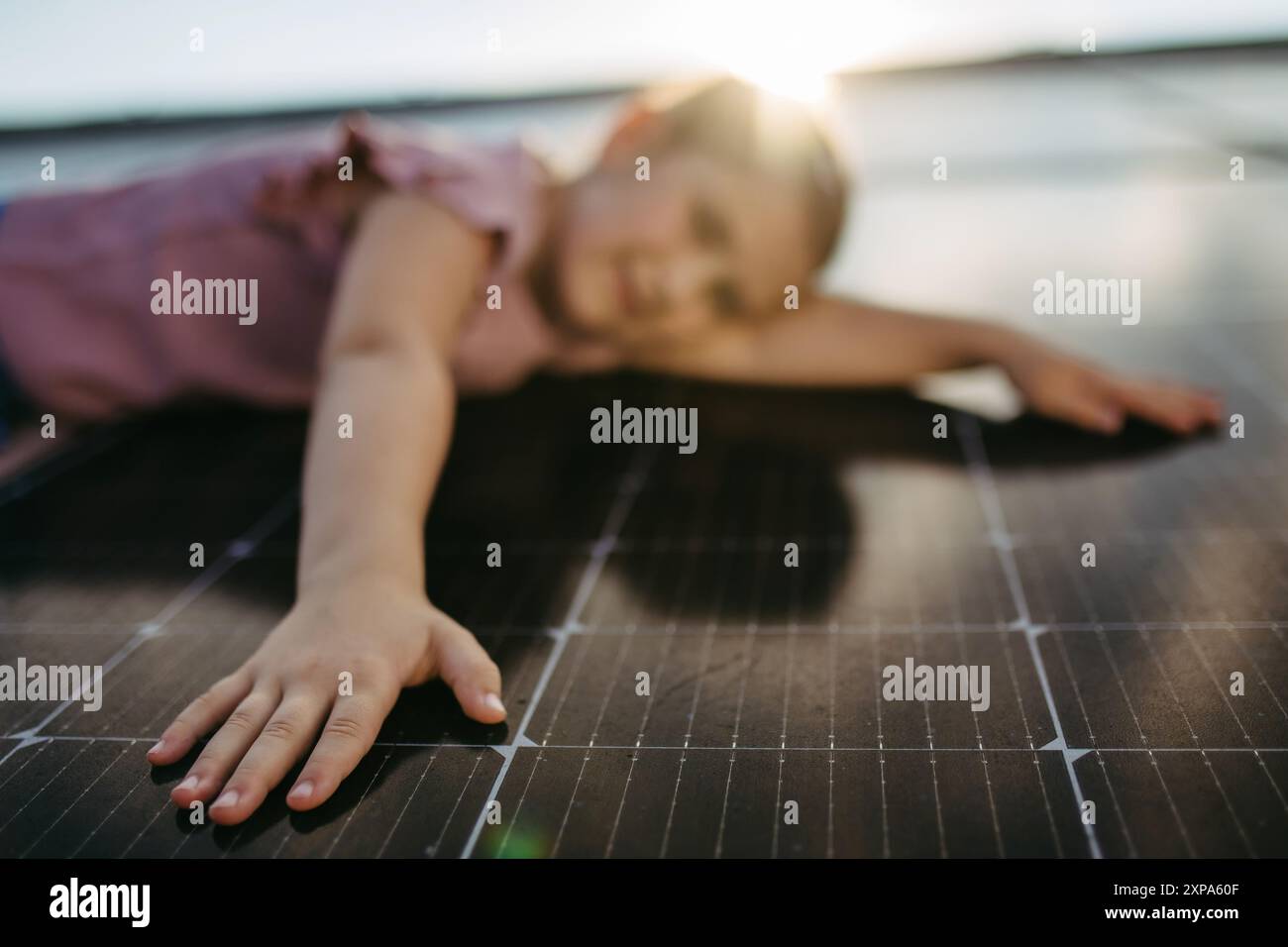Cute girl lying on solar panels roof, close up on hand. Rooftop solar ...