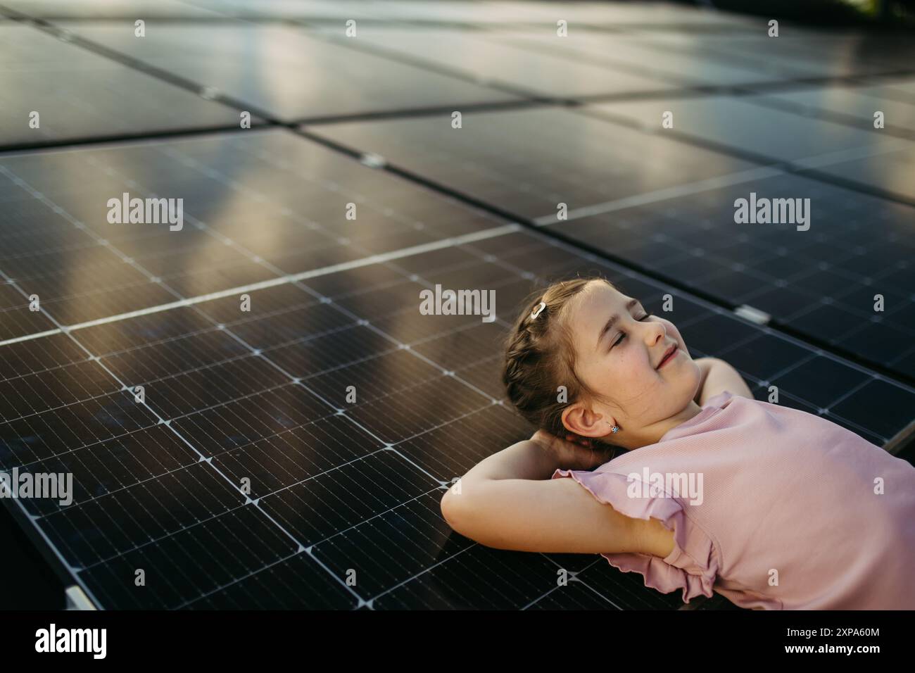 Cute girl lying on solar panels roof, shot with copy space. Rooftop ...