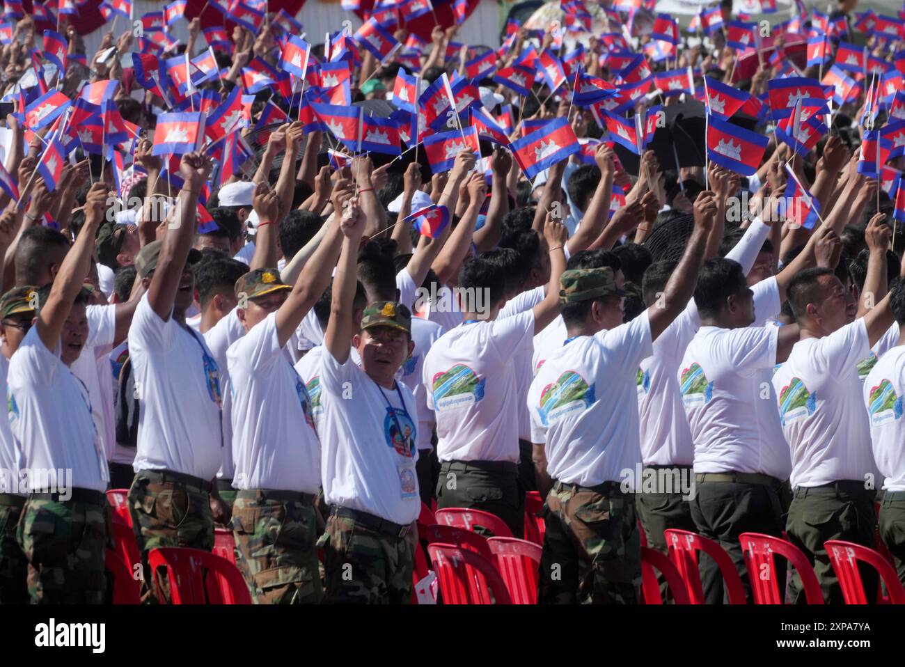 Cambodian army personnel wave their national flags during a ...