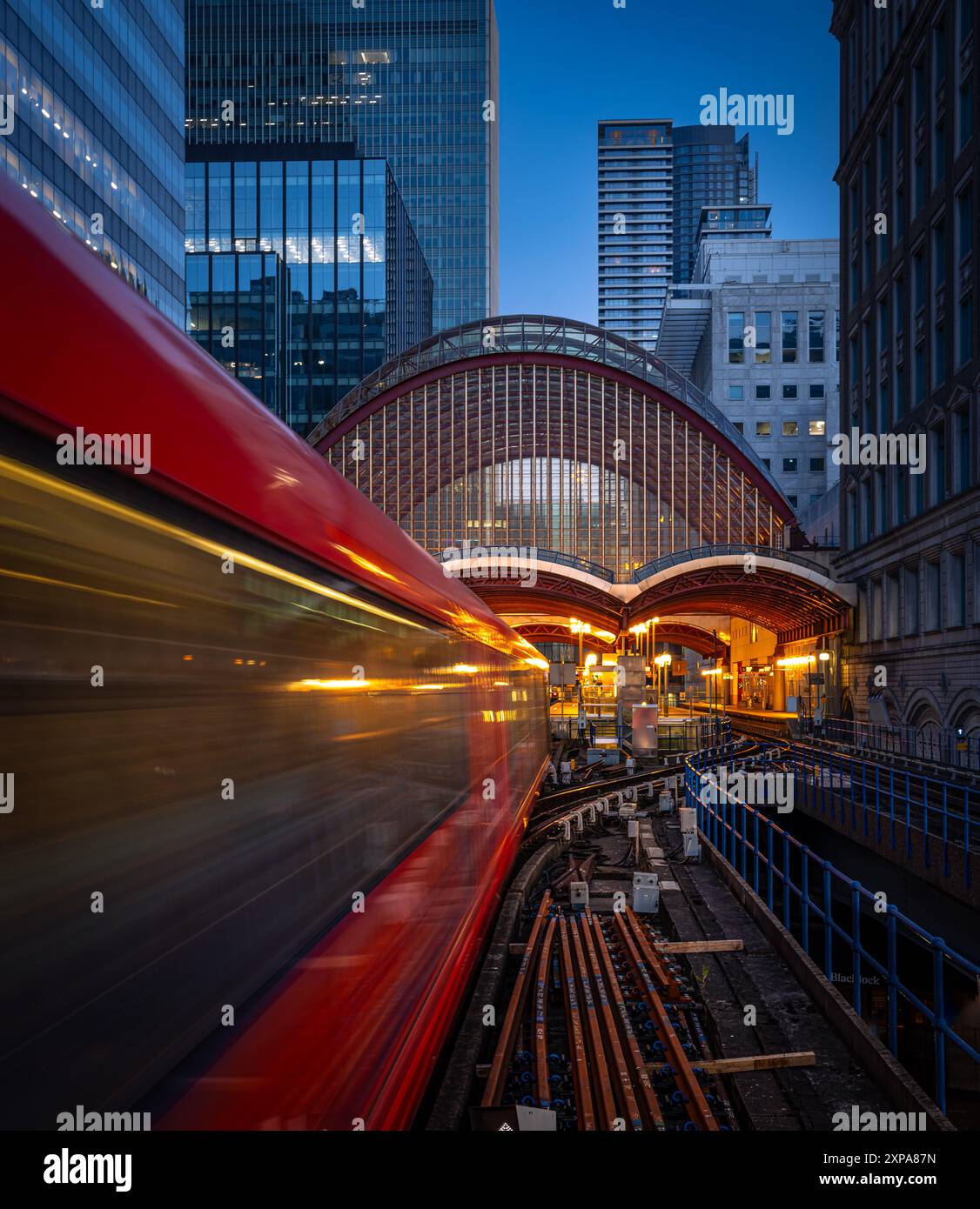 A vibrant red London underground subway train is traveling through ...