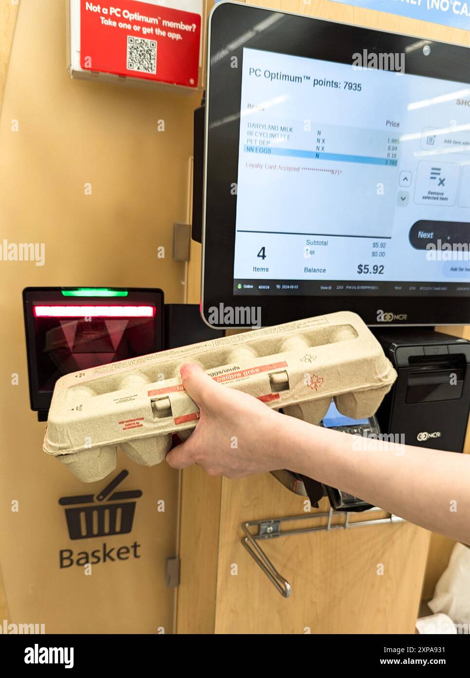 A woman scans the egg at a self-checkout counter at Shoppers Drug Mart ...