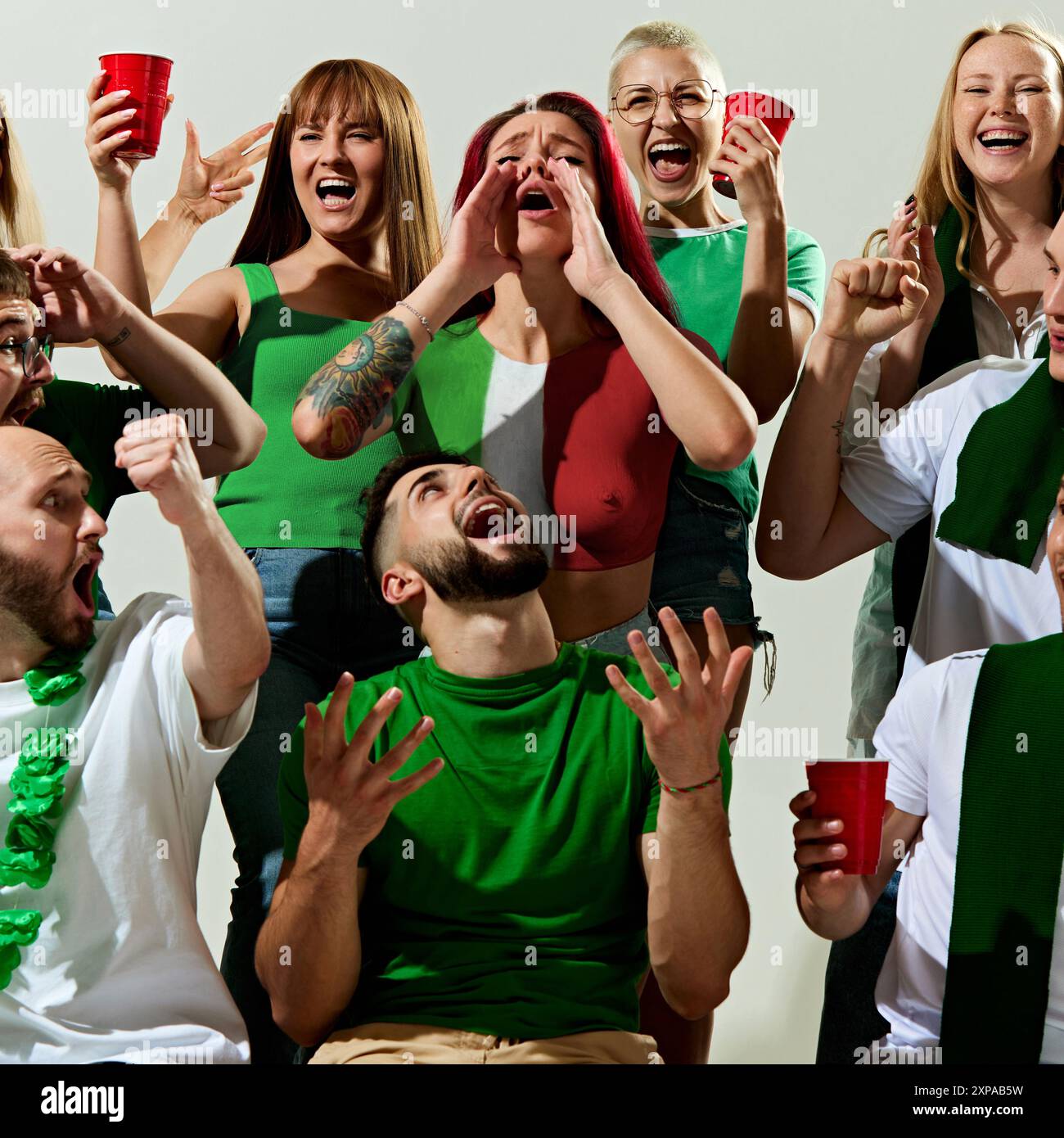 Goal. Super emotional young people, men and women in matching green ...