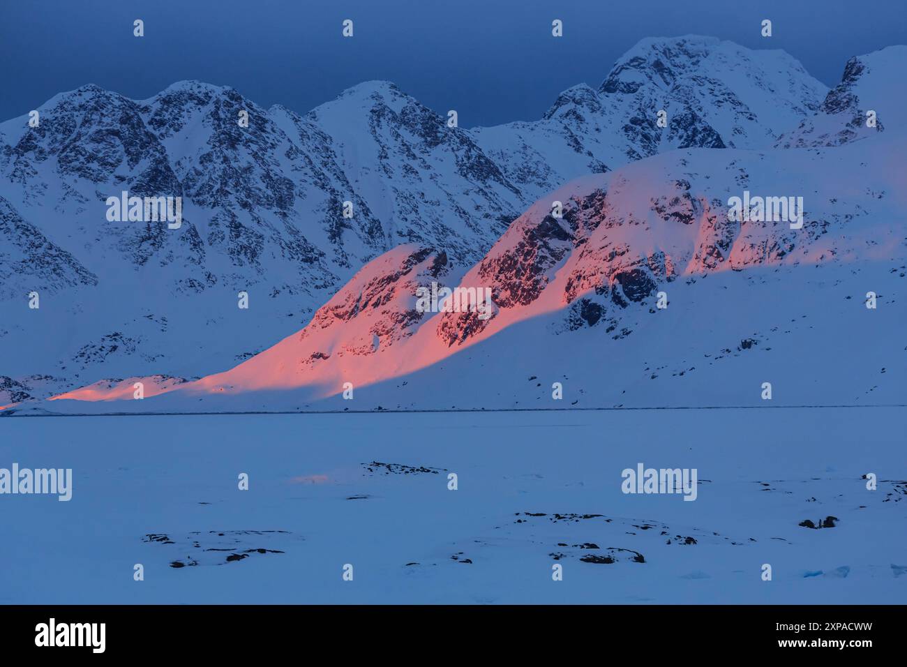 Evening light on steep mountains in winter, Kulusuk, East Greenland ...