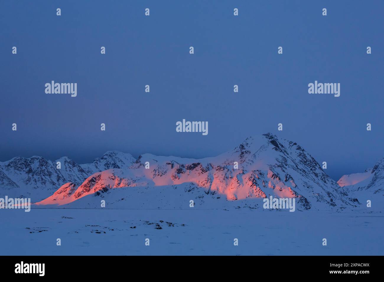 Evening light on steep mountains in winter, Kulusuk, East Greenland ...