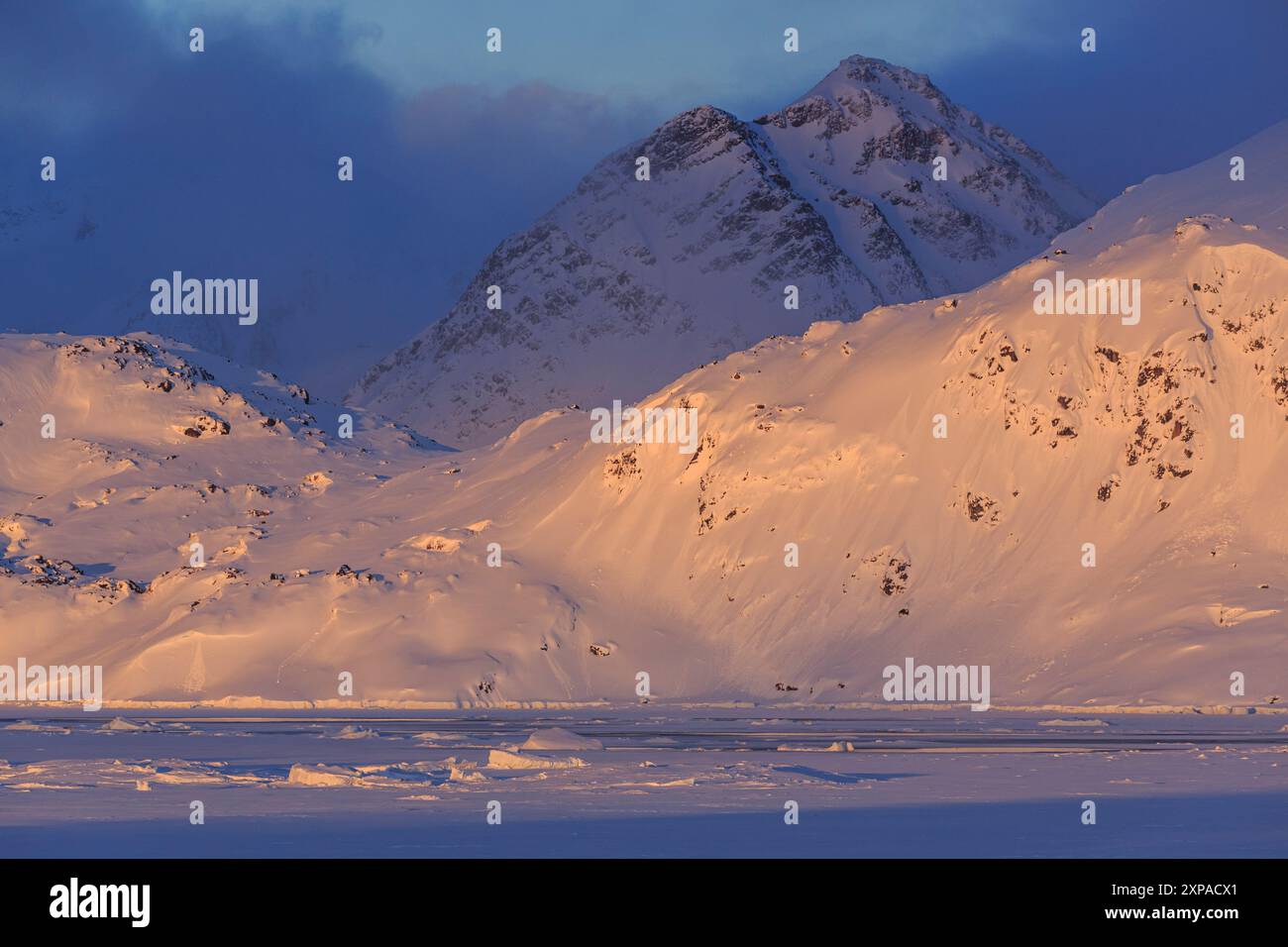 Evening light on steep mountains in winter, Kulusuk, East Greenland ...