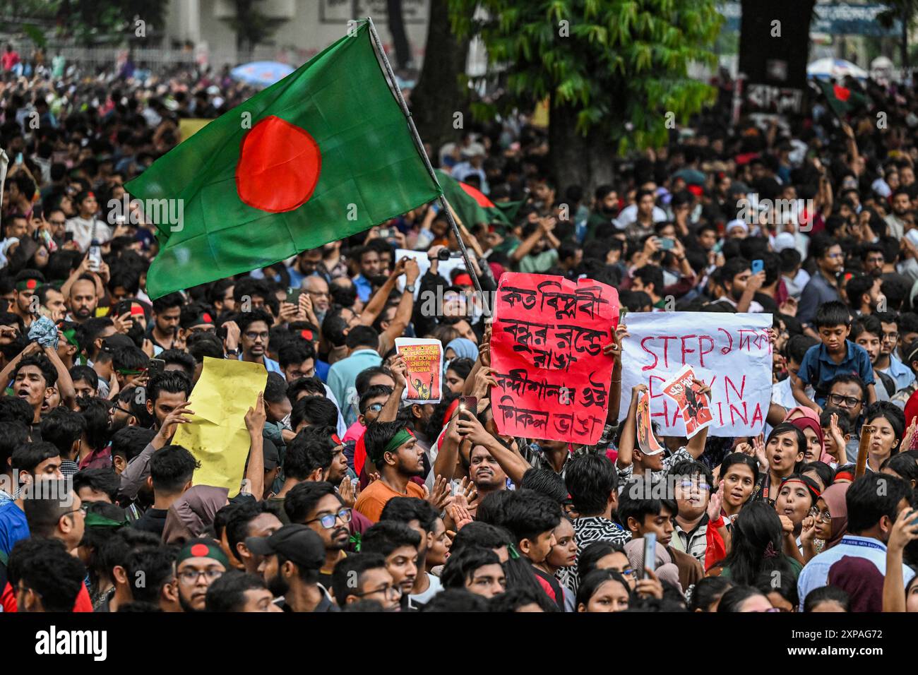 Bangladeshi students wave flag and hold placards expressing their ...