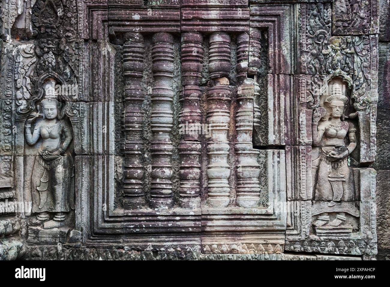 Ta Prohm temple wall decorated with columns in blind window and apsaras ...