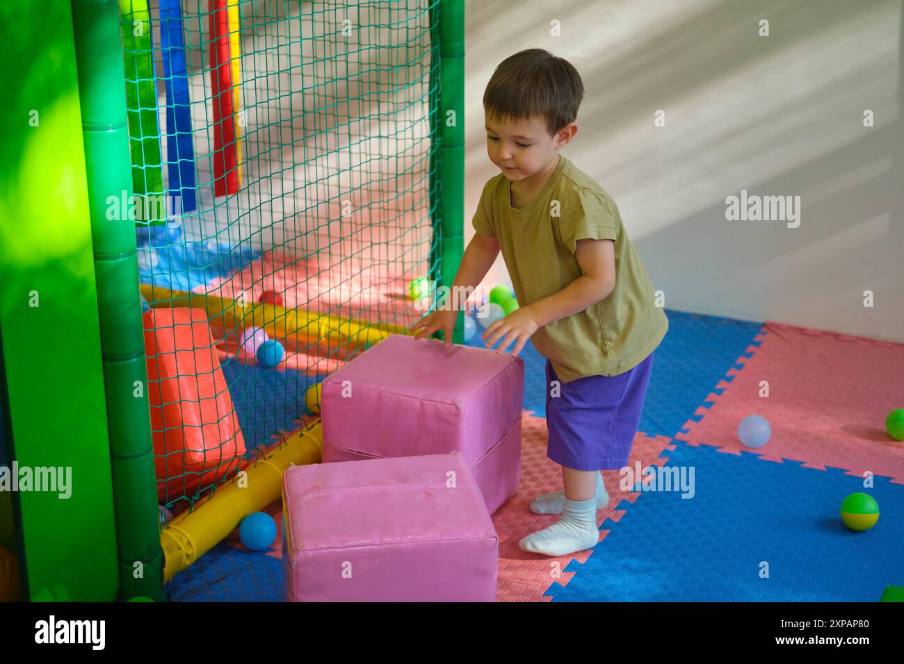 Child playing with soft blocks in indoor playground. Indoor playground ...