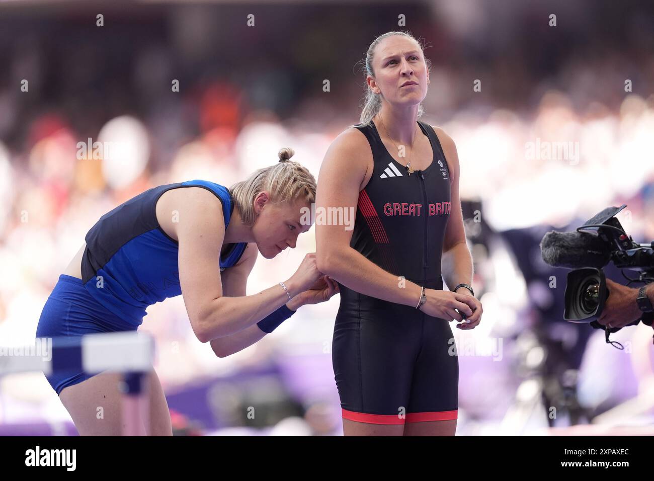 Finland's Wilma Murto (left) fixes the number on the back of Great ...