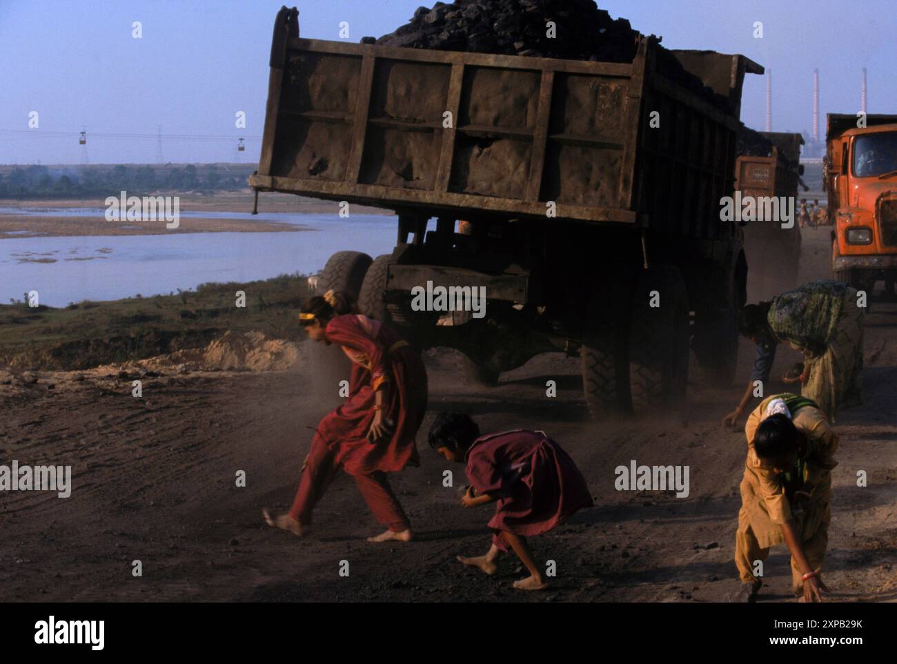 People pick up coal dropped by trucks in Madhya Pradesh, India Stock ...
