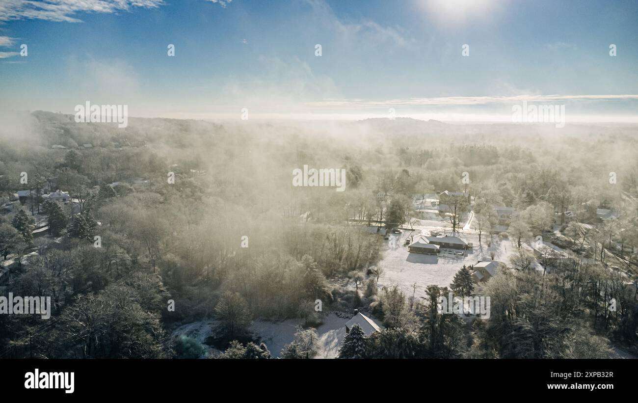 Aerial view of a foggy, snowy landscape with trees and houses Stock ...