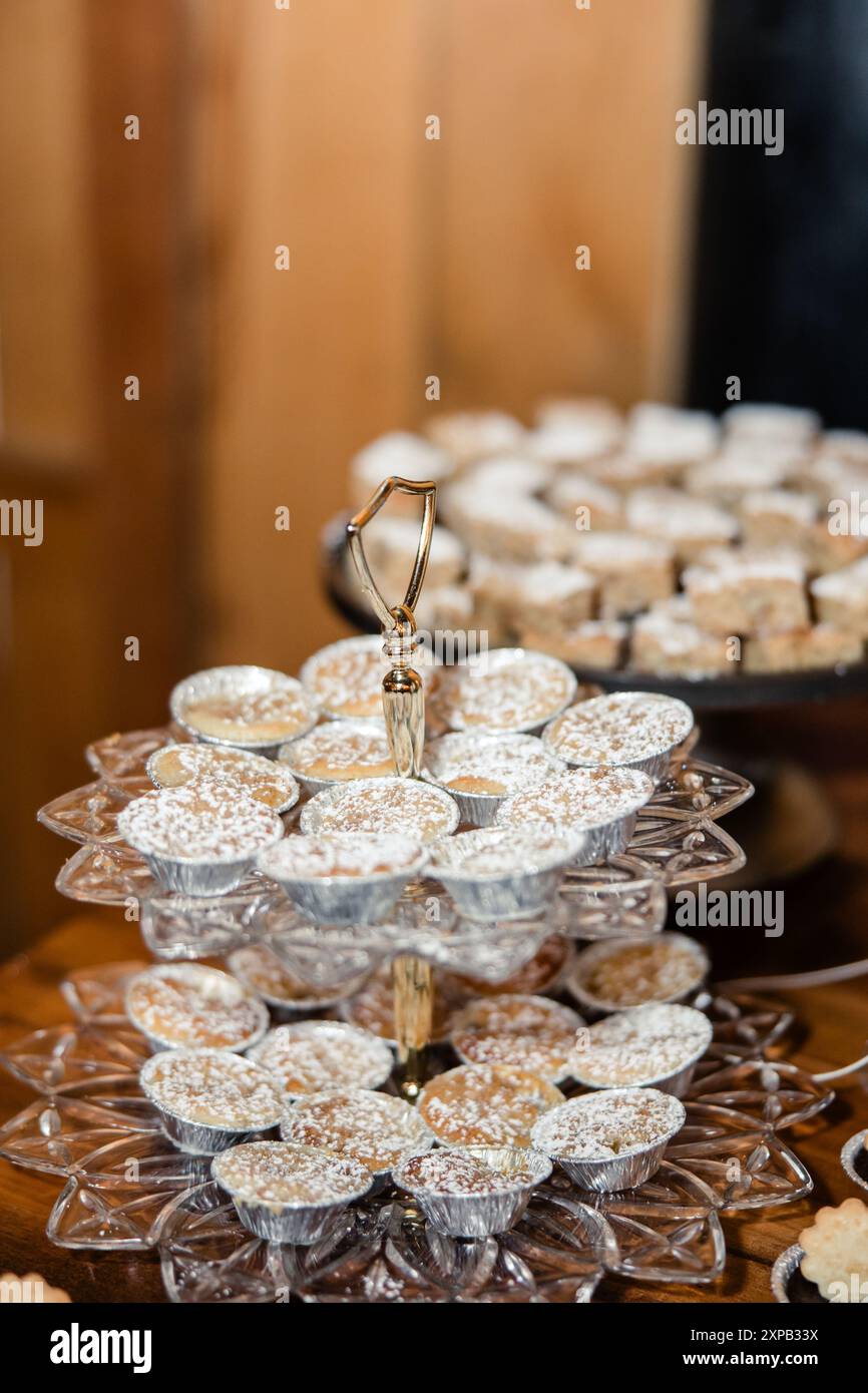 Mini powdered sugar desserts arranged on a tiered stand Stock Photo - Alamy