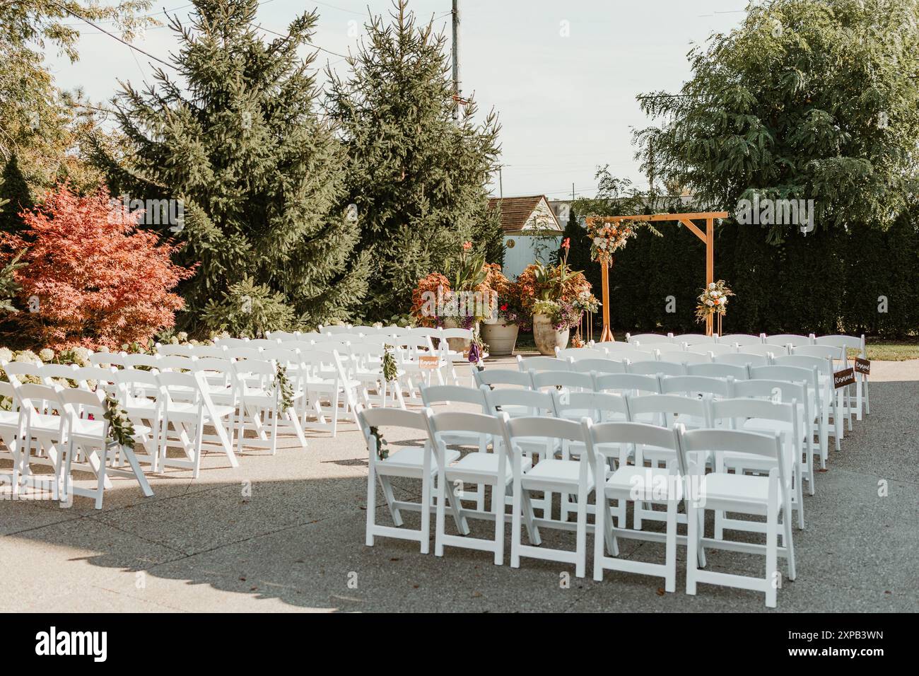 Outdoor wedding ceremony setup with white chairs and floral arch Stock ...