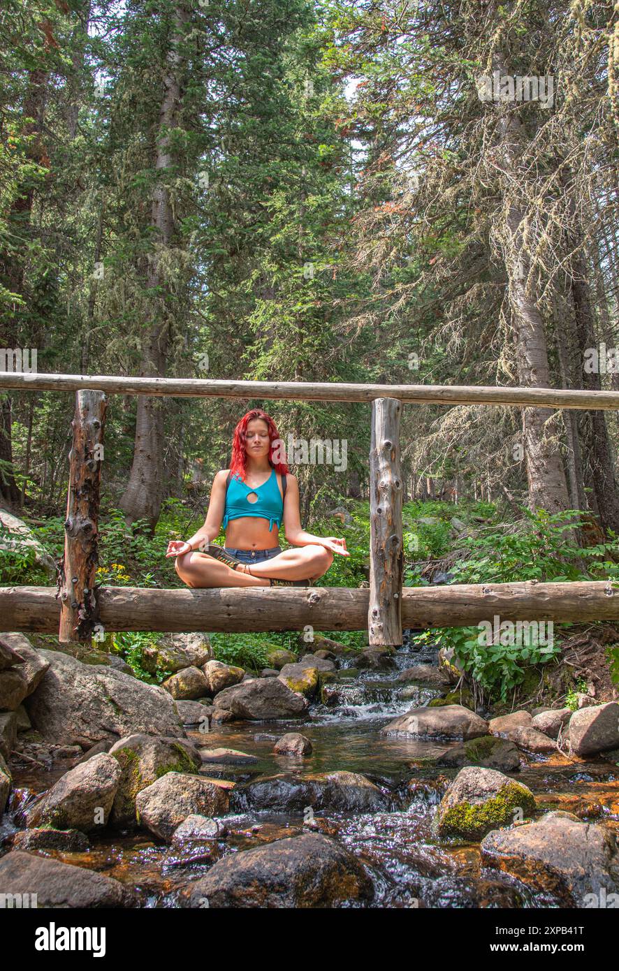 Woman mediates on a bridge Stock Photo - Alamy