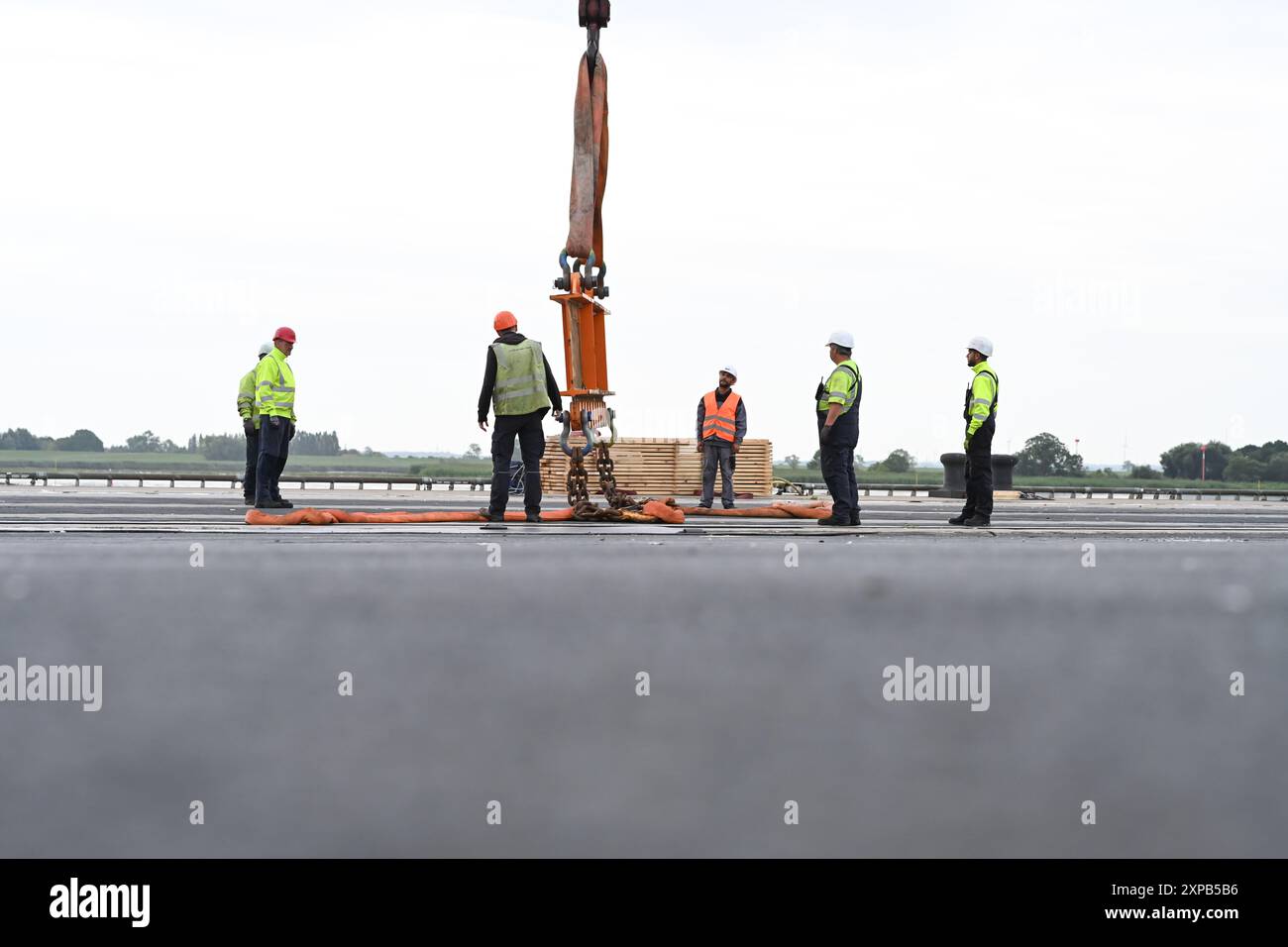 Brake, Germany. 05th Aug, 2024. Port workers look at the loading gear ...