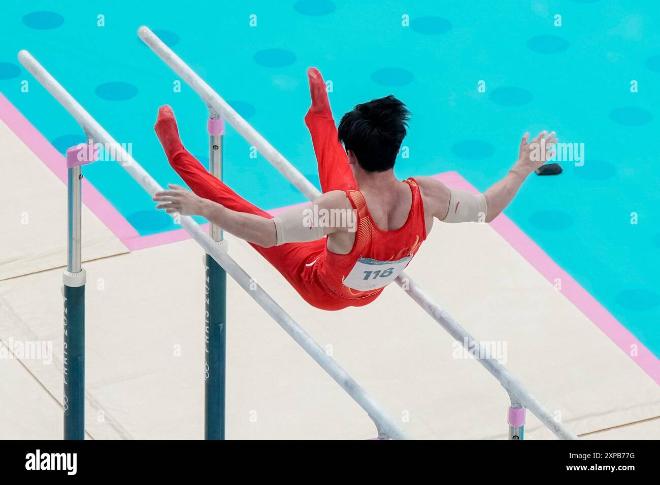 Zhang Boheng, of China, performs on the parallel bars during the men's ...