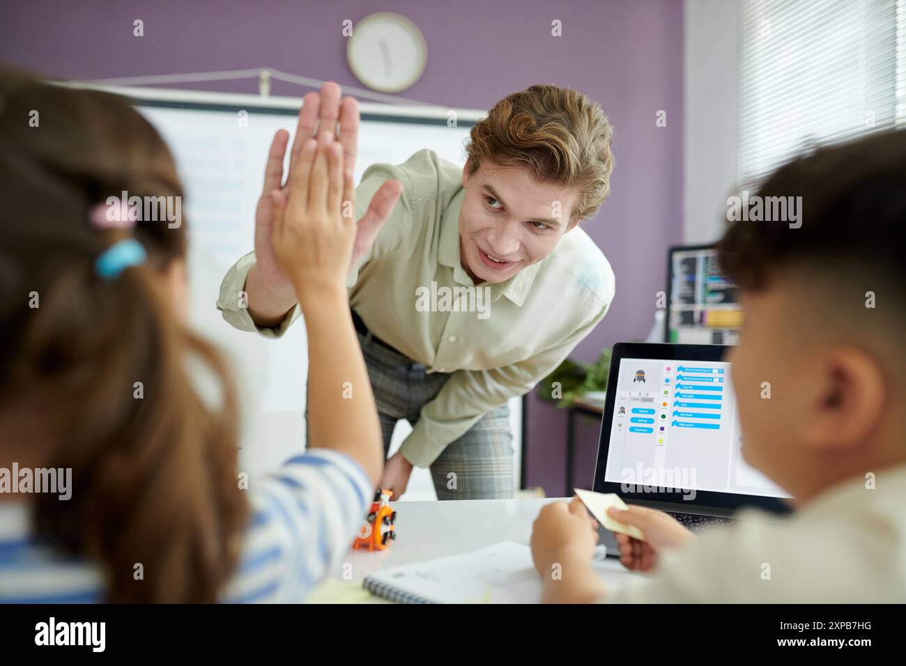 School Teacher Interacting with Students in Classroom Stock Photo - Alamy