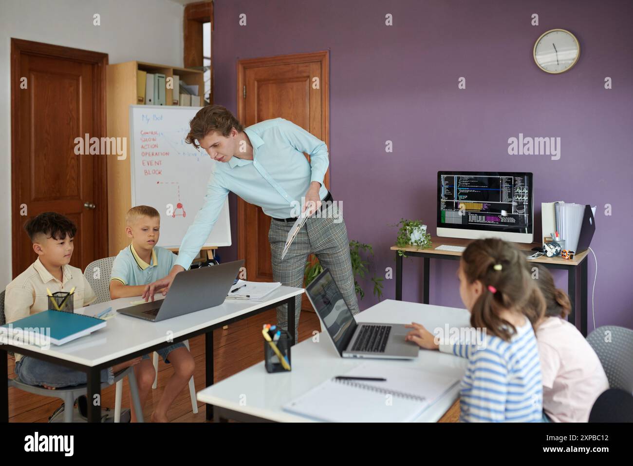 Teacher Engaging Students in Classroom Setting with Laptops Stock Photo ...