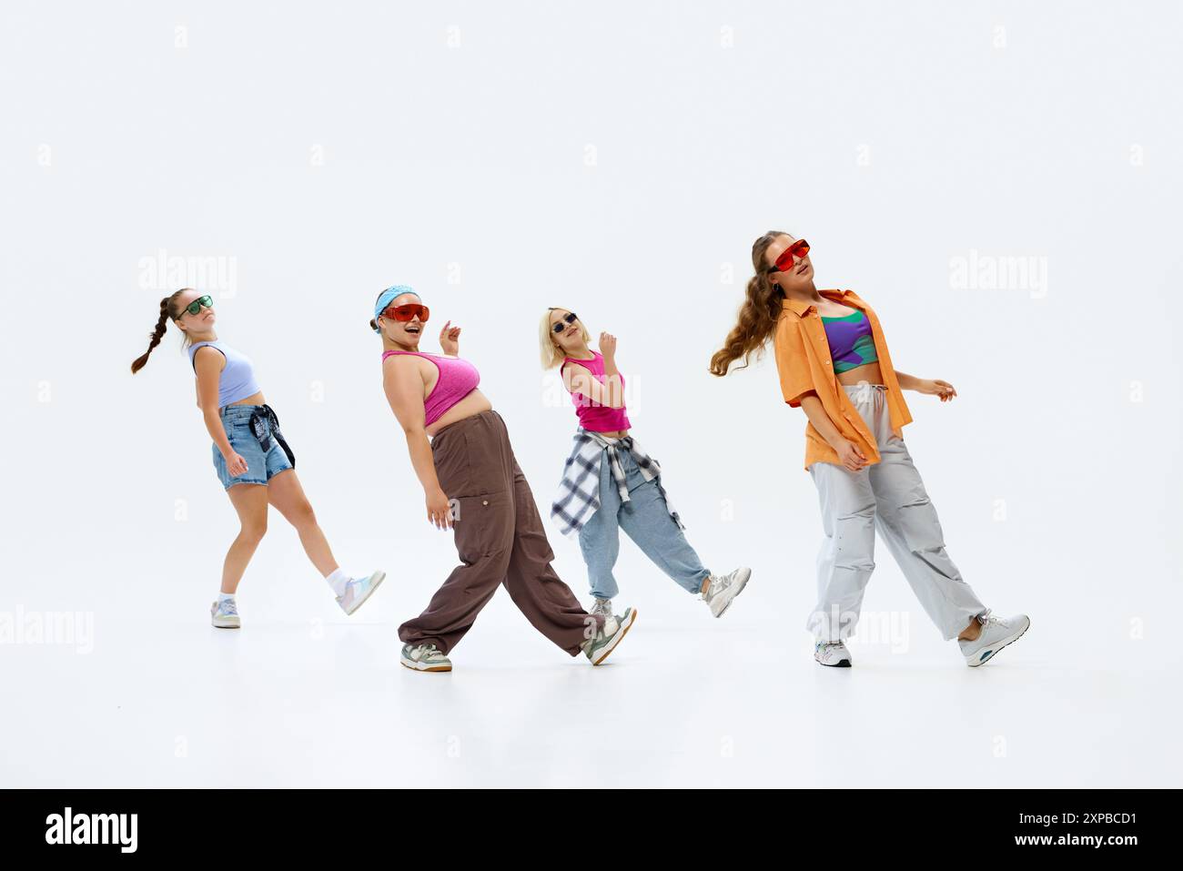 Dancers in trendy, colorful clothing and sunglasses strike coordinated ...