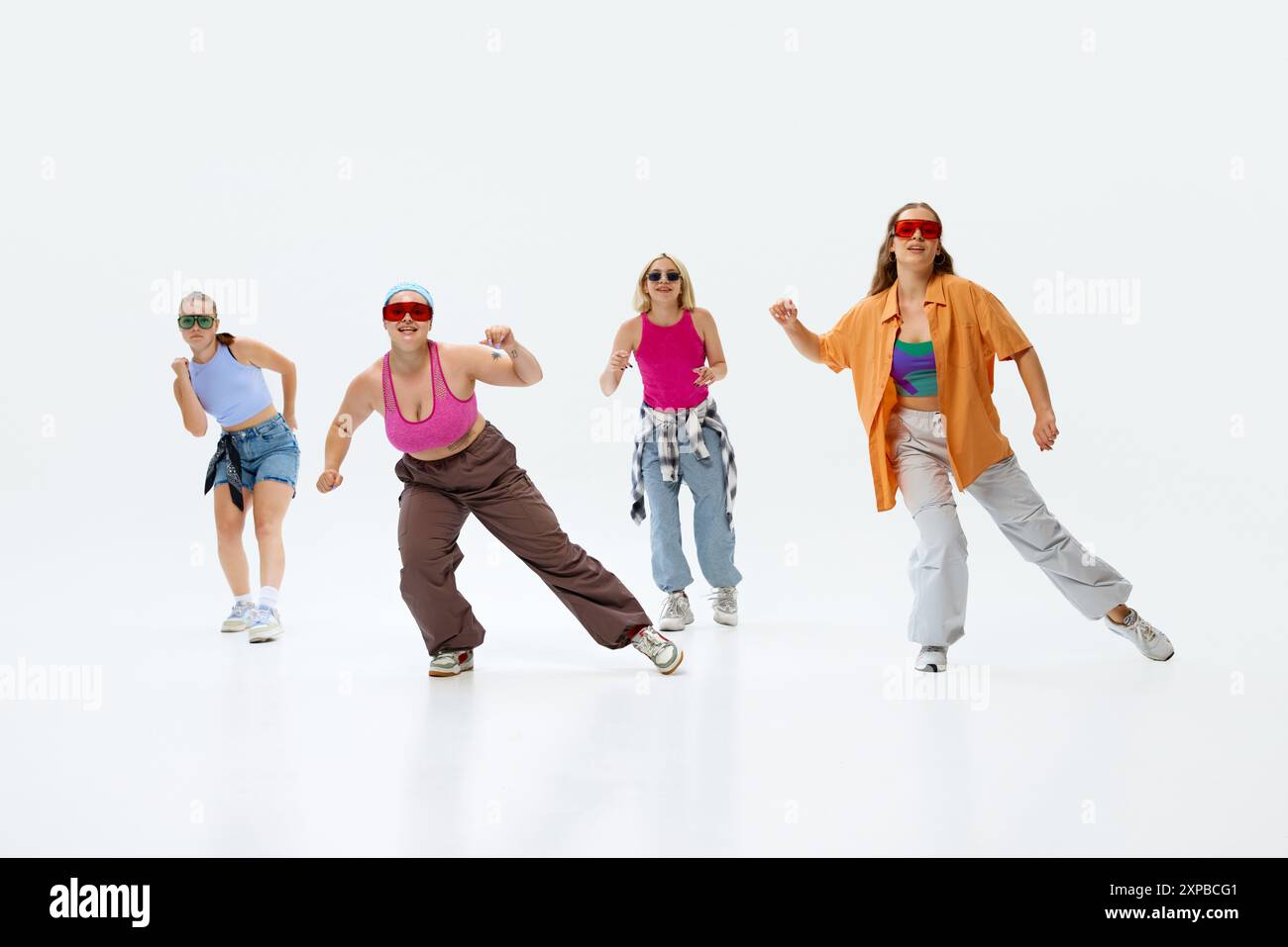 Dressed in bright, casual outfits and sunglasses, four dancers pose ...