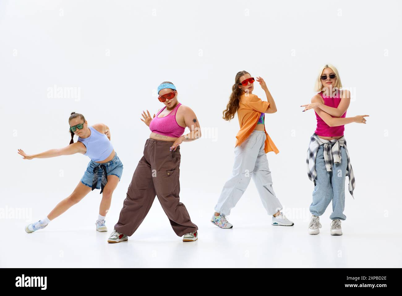 Diverse group of four dancers in vibrant streetwear and sunglasses pose ...