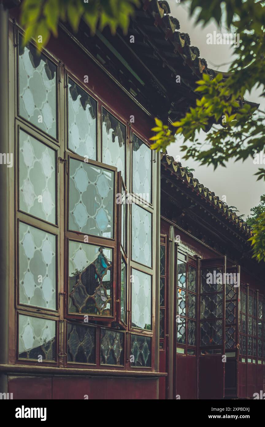 A traditional Chinese building with a tiled roof and windows with ...