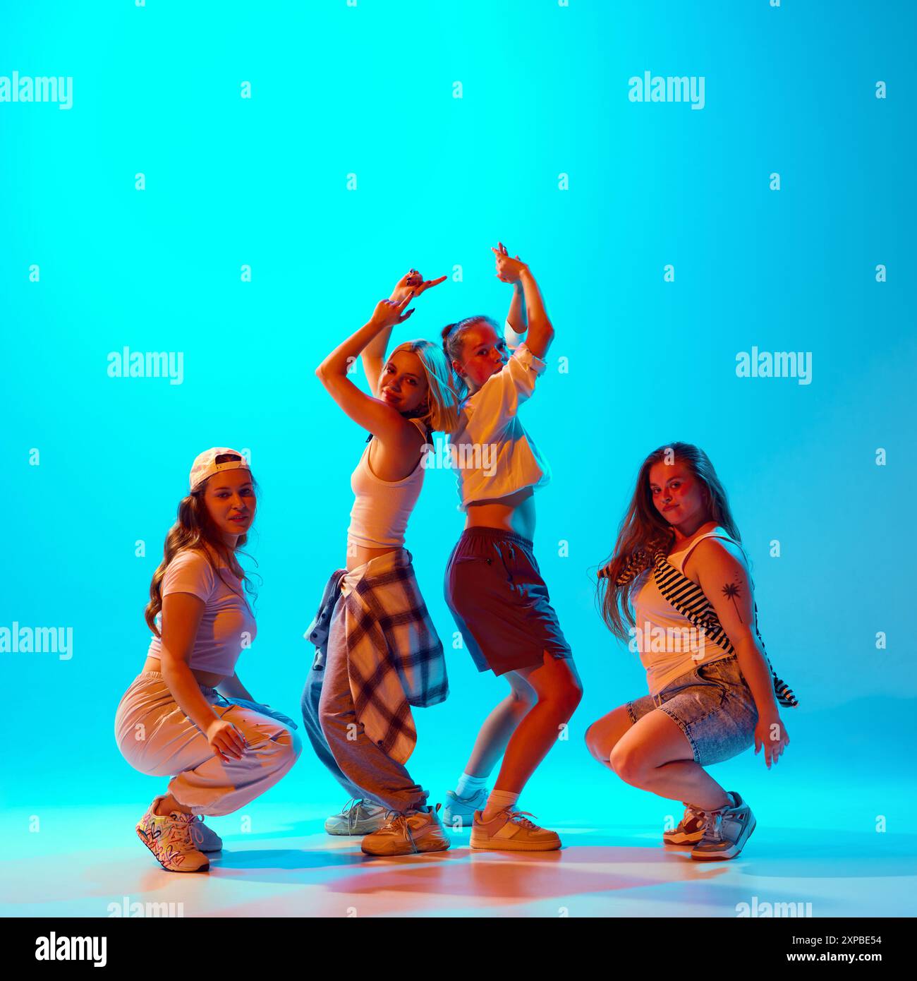 Talented dancers in casual outfits strike stylish poses against blue ...