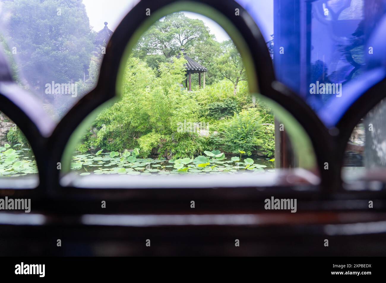 Suzhou, China - June 11, 2024 : A view of a Chinese garden through a ...