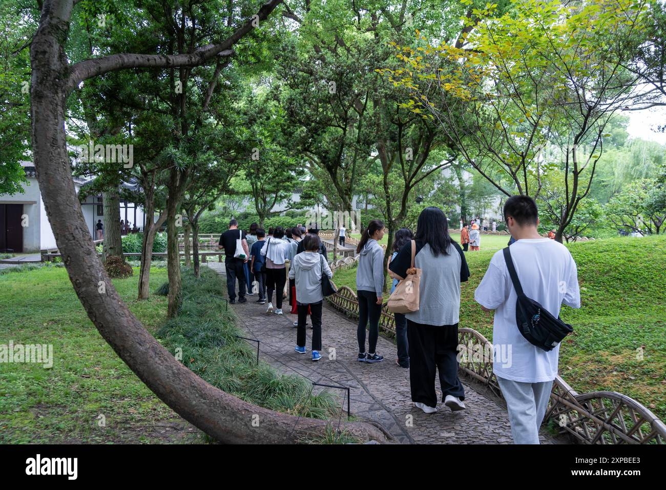 Suzhou, China - June 11, 2024 : A group of people walk along a path in ...