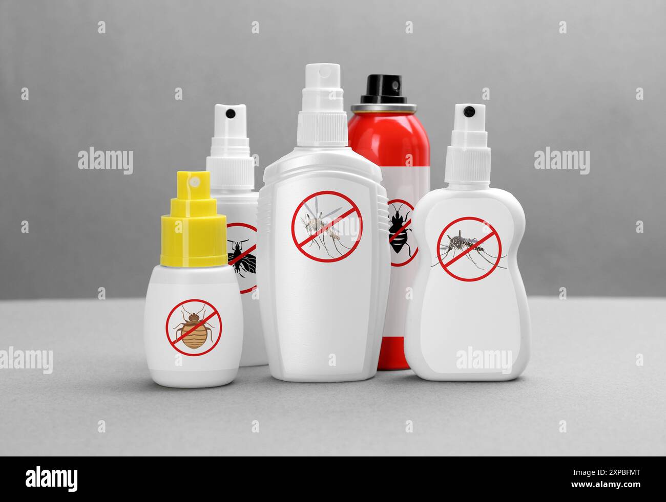 Different insect repellents in spray bottles on grey background Stock ...