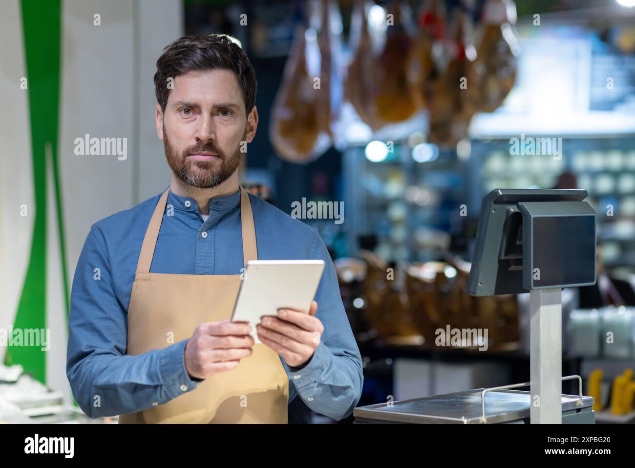 Store employee using digital tablet at checkout counter in grocery ...